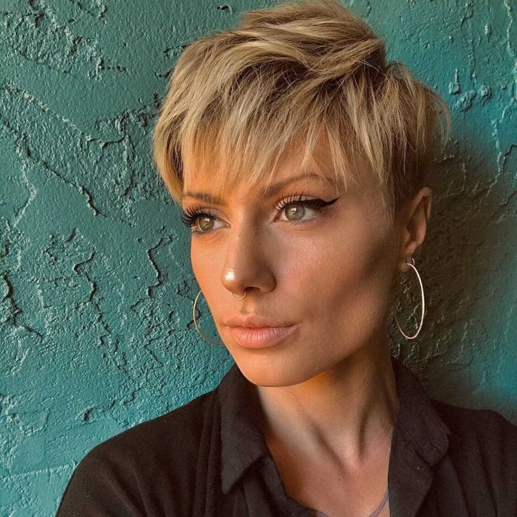 Taglio di capelli corto, un pixie cut biondo con frangia e lati rasati